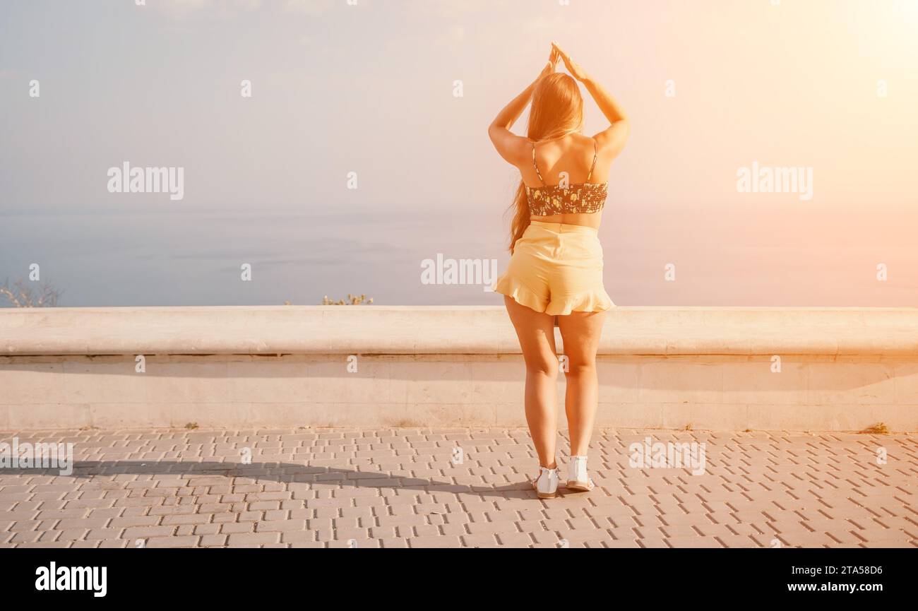 Frauen-Sommertanz. Silhouette einer glücklichen Frau, die tanzt, sich dreht und ihre Hände zum ...