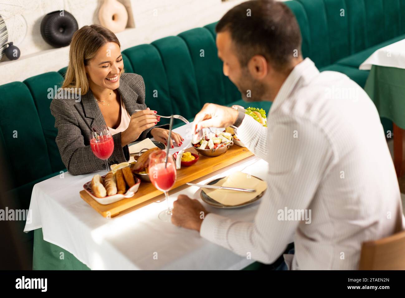 Ein junges Paar beim Mittagessen und beim Trinken von frisch gepresstem ...