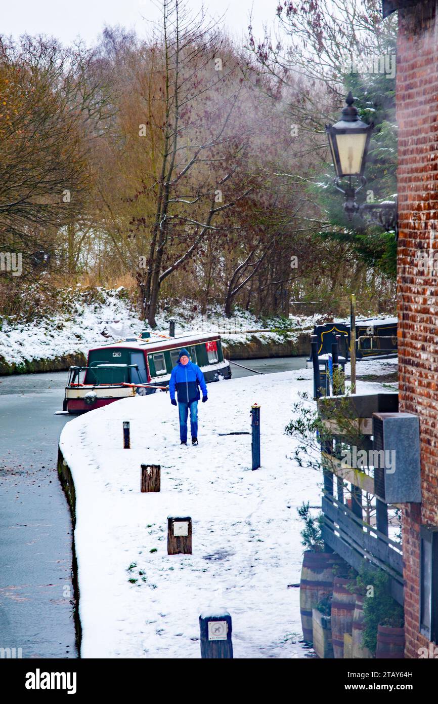 Mann, der im Winter im Wheelock Cheshire England im Schnee an einem ...