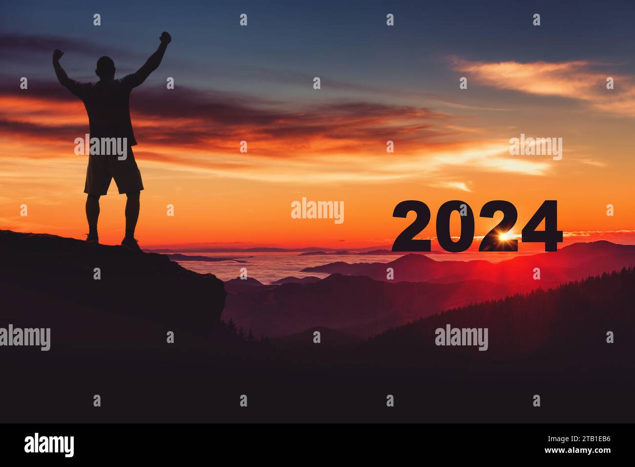 Die Silhouette des Mannes auf dem Gipfel des Berges beobachtet den Sonnenaufgang und den ...