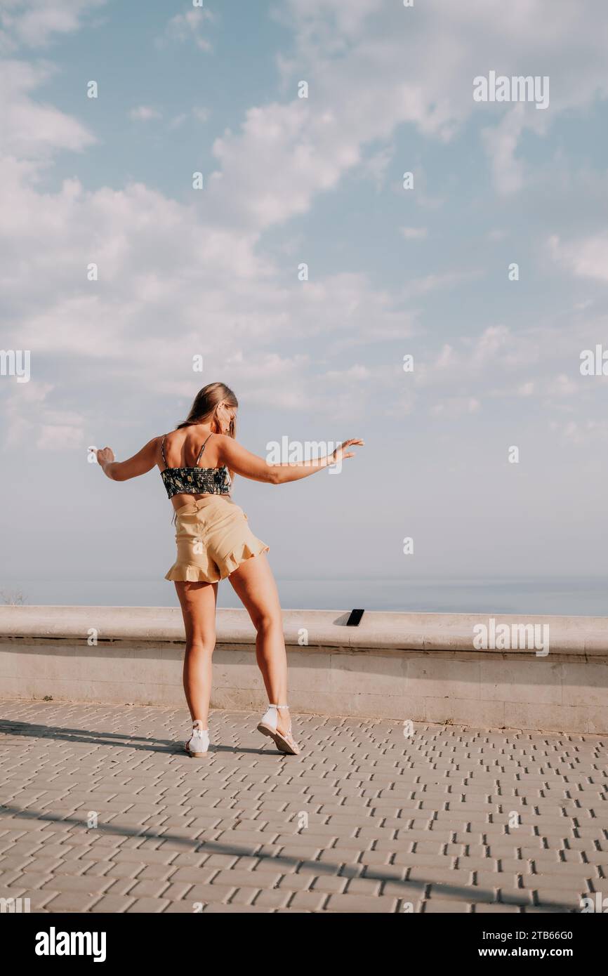 Frauen-Sommertanz. Silhouette einer glücklichen Frau, die tanzt, sich dreht und ihre Hände zum ...