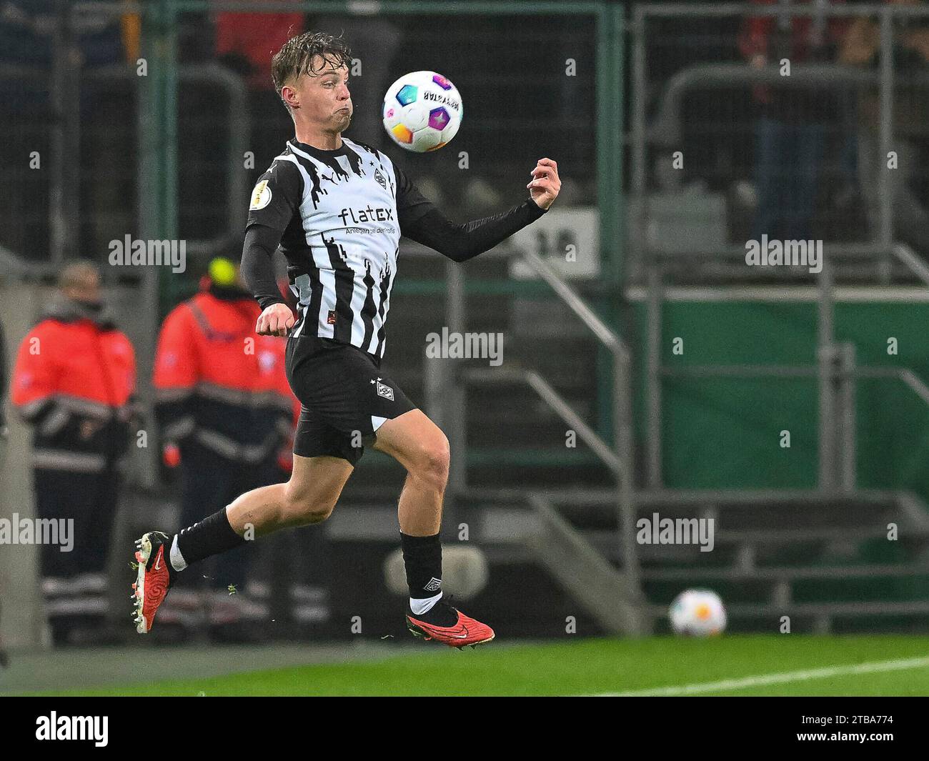 Luca Netz (Borussia Mönchengladbach, #20) nimmt den Ball in der Luft ...