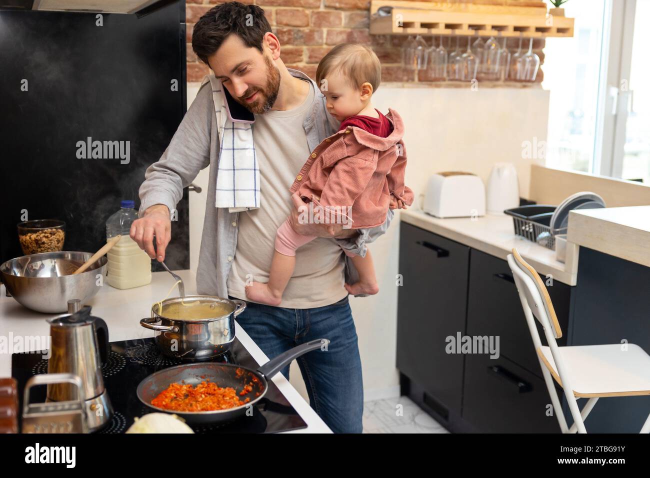 Ein beschäftigter Vater kümmert sich um ein Mädchen, das Essen macht ...