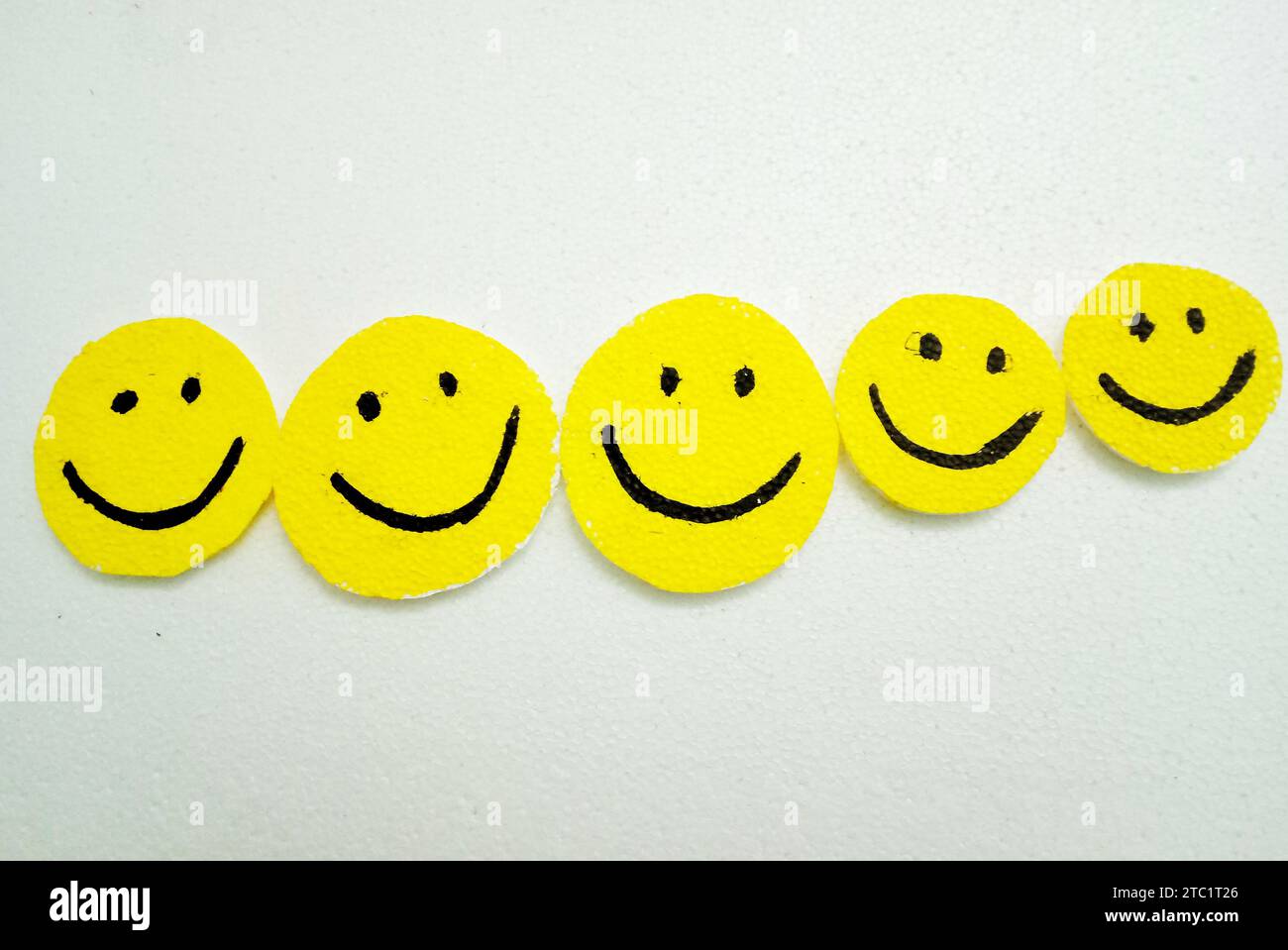 Handgefertigte Smiley-Symbole auf weißem Hintergrund. Glücklich, Freude, Lächeln, positive Vibes ...