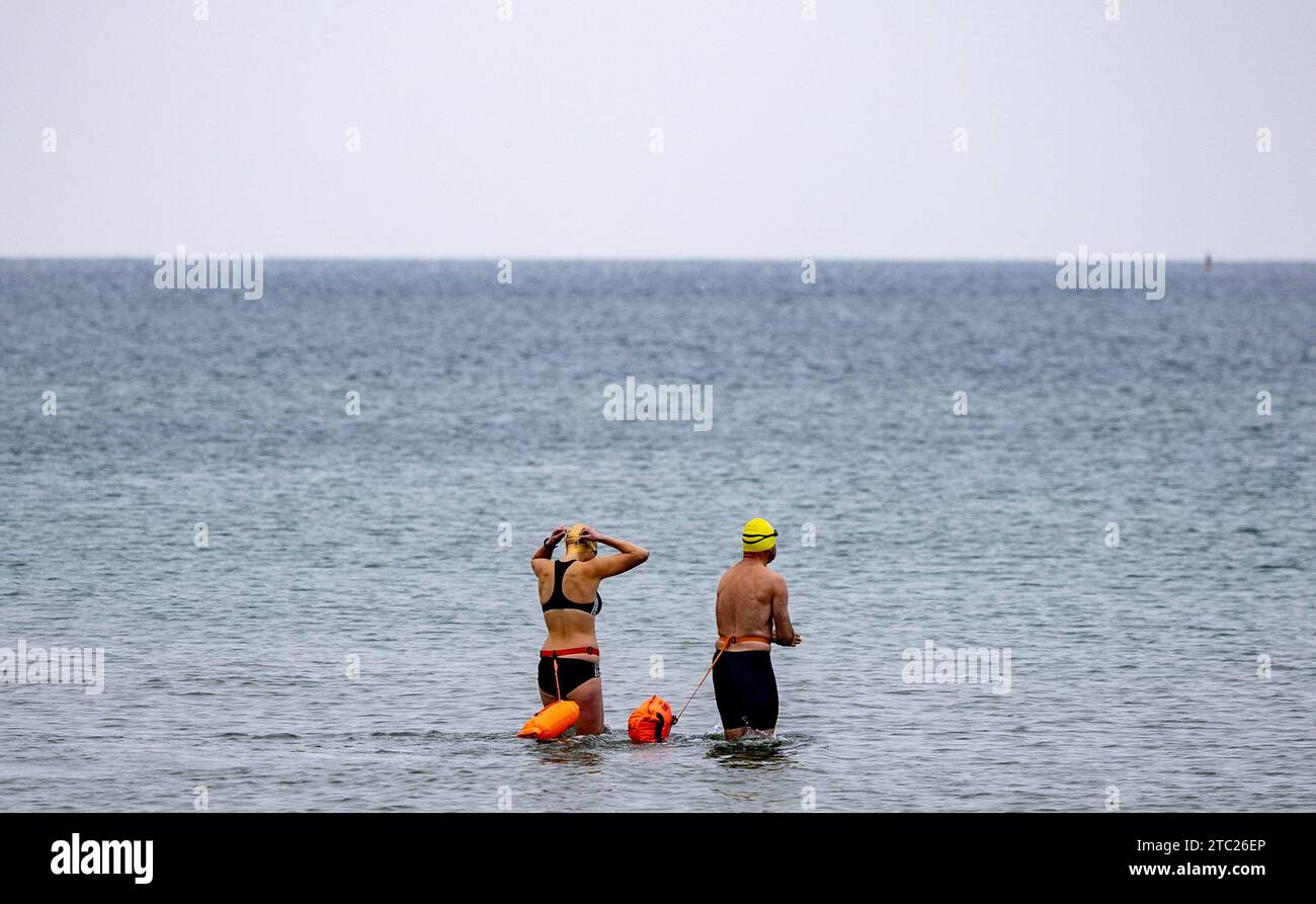 10. Dezember 2023, Mecklenburg-Vorpommern, Warnemünde: Zwei Schwimmer ...