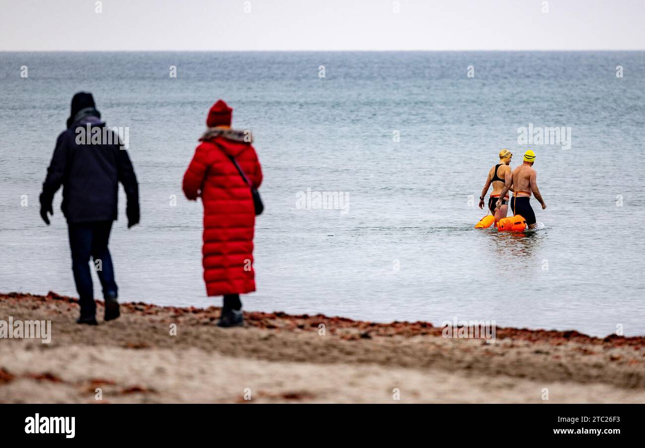 10. Dezember 2023, Mecklenburg-Vorpommern, Warnemünde: Zwei Schwimmer ...
