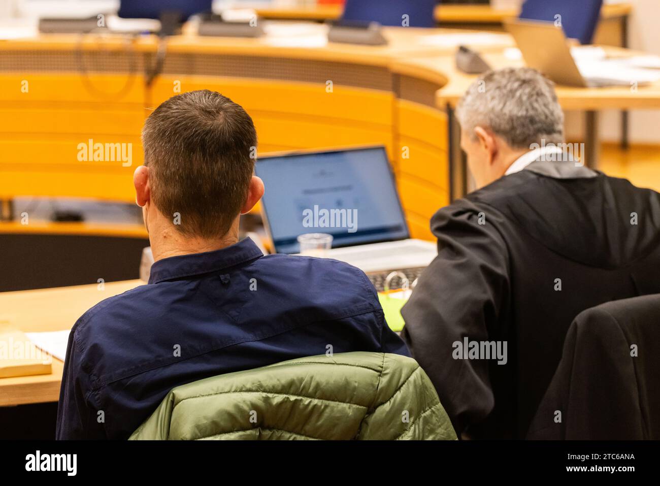 11. Dezember 2023, Baden-Württemberg, Waldshut-Tiengen: Ein Angeklagter (l) sitzt neben seinem ...
