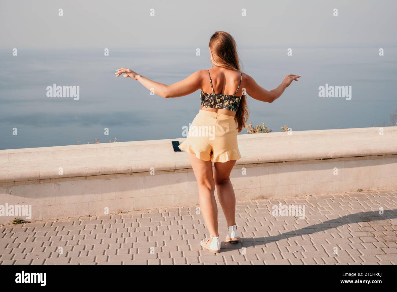 Frauen-Sommertanz. Silhouette einer glücklichen Frau, die tanzt, sich dreht und ihre Hände zum ...