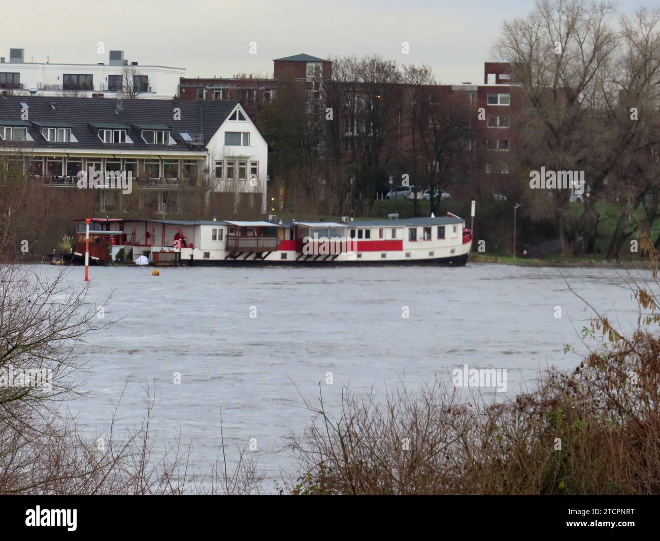 Blick ueber den Hochwasser Rheinstrom auf das Bootshaus Bottke bei ...