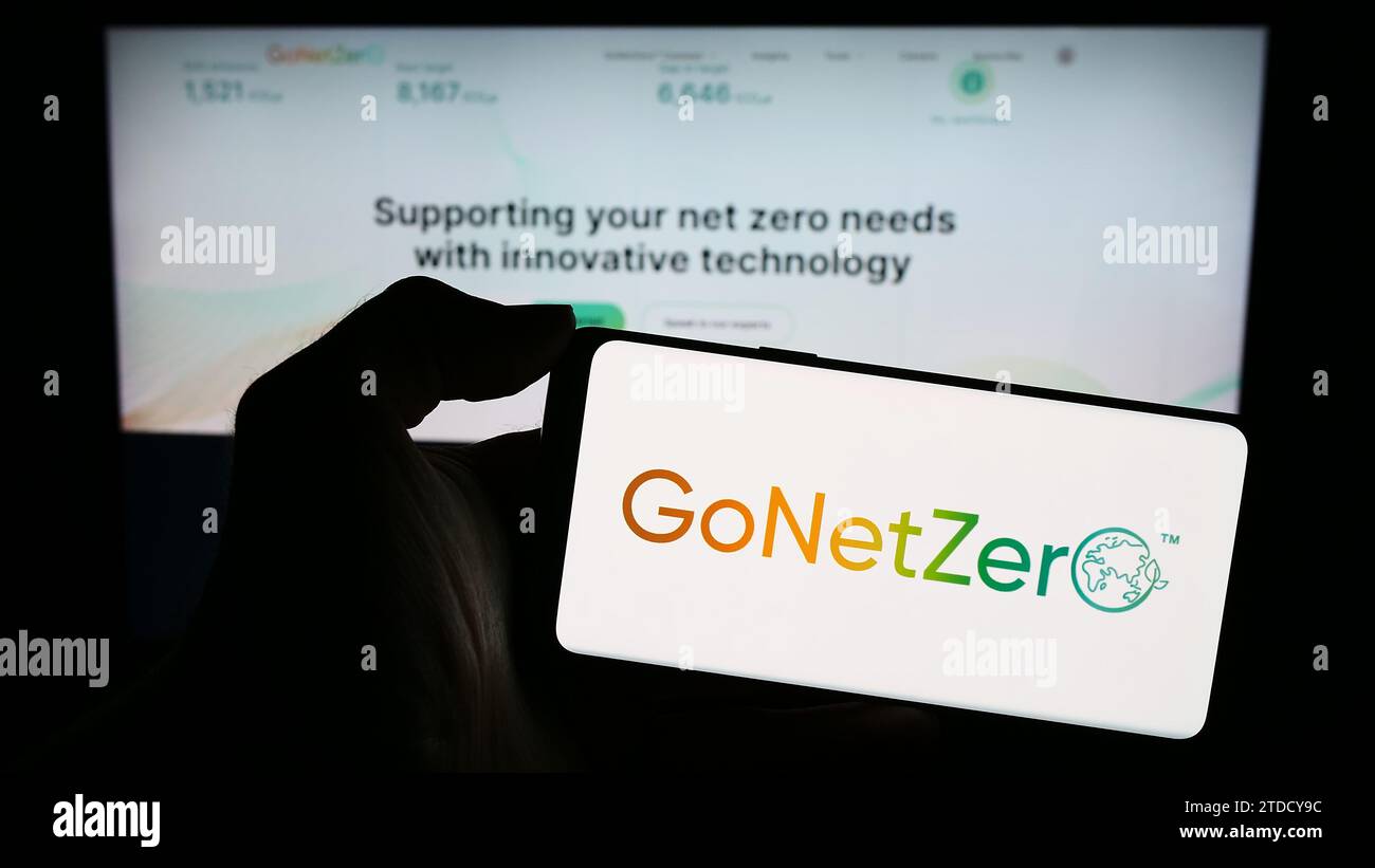 Person, die ein Mobiltelefon mit dem Logo des singapurischen CO2 ...