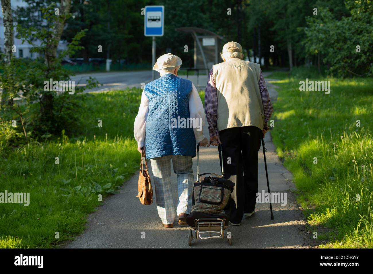 Der alte Mann und die alte Frau tragen einen Wagen. Ältere Menschen ...