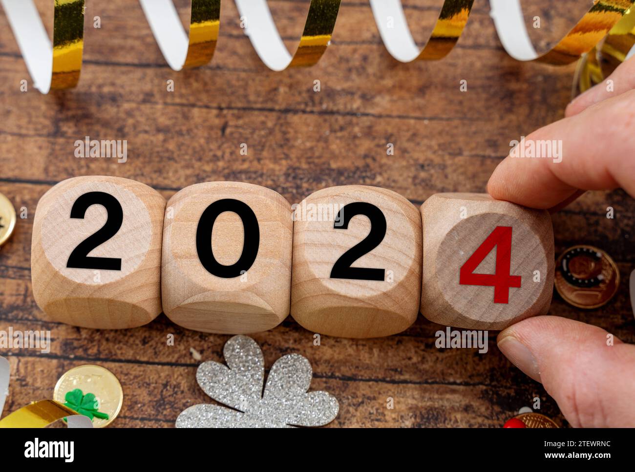 19. Dezember 2023: Jahreswende von 2023 bis 2024 und Silvesterkonzept. Hand dreht Holzwürfel zum ...