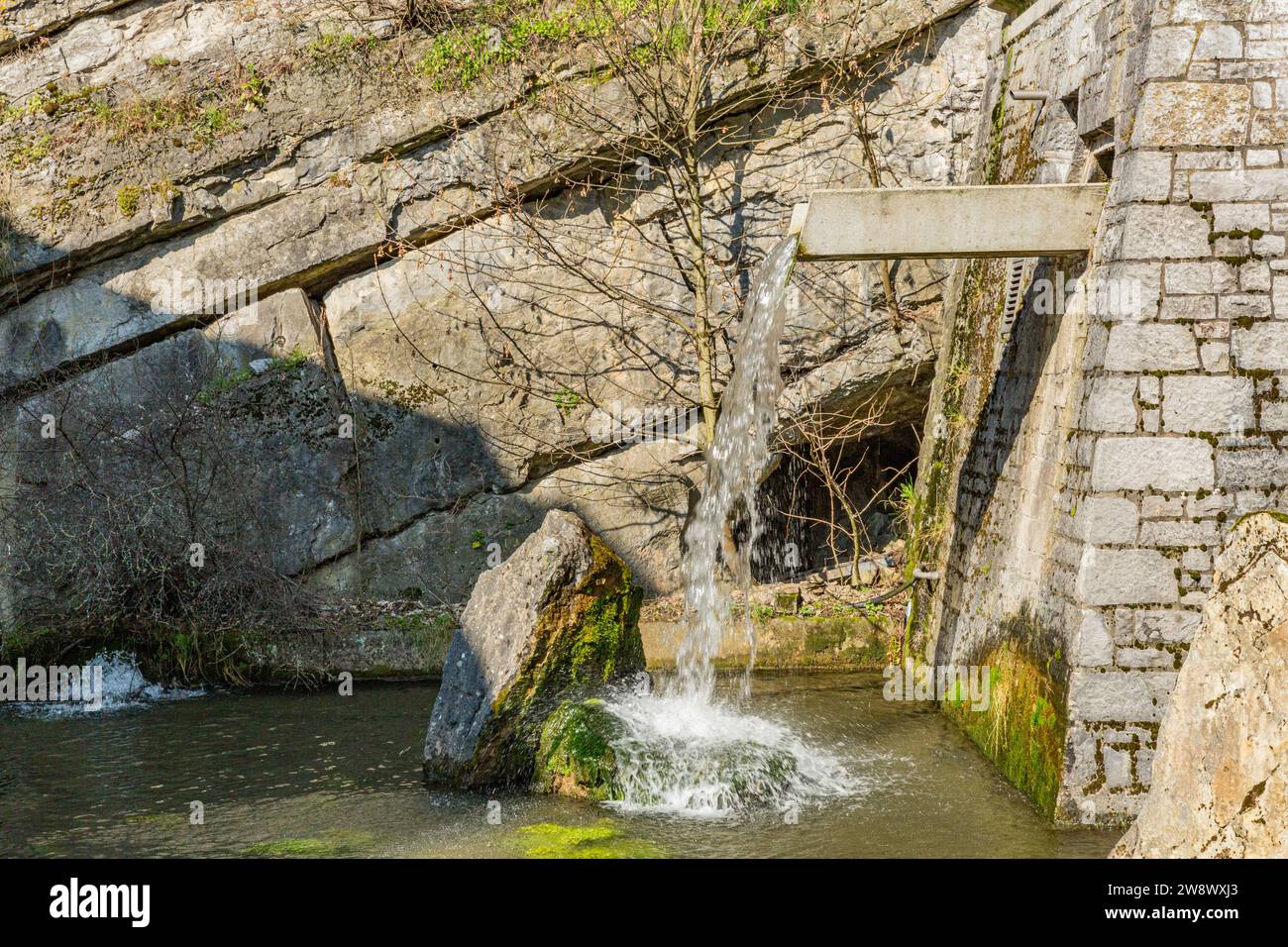 Kristallklares, sauberes Wasser sprudelt vom Brunnen auf einen Stein ...