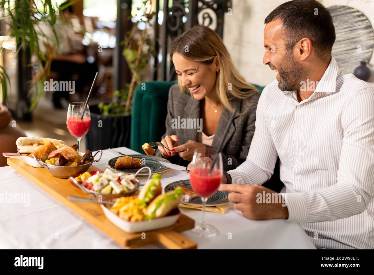Ein junges Paar beim Mittagessen und beim Trinken von frisch gepresstem ...