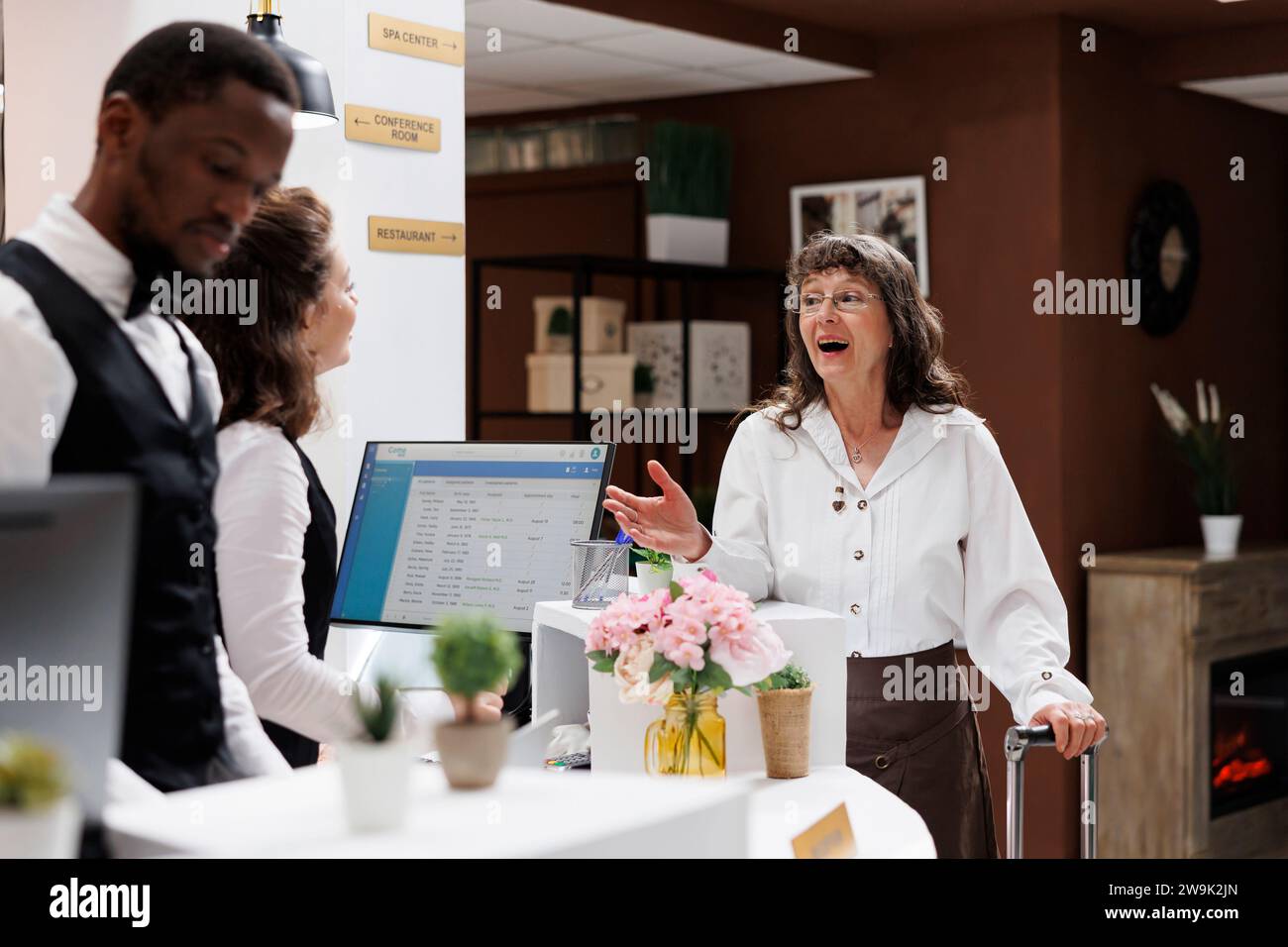 In der Hotellobby begrüßt das freundliche Personal Seniorinnen im ...