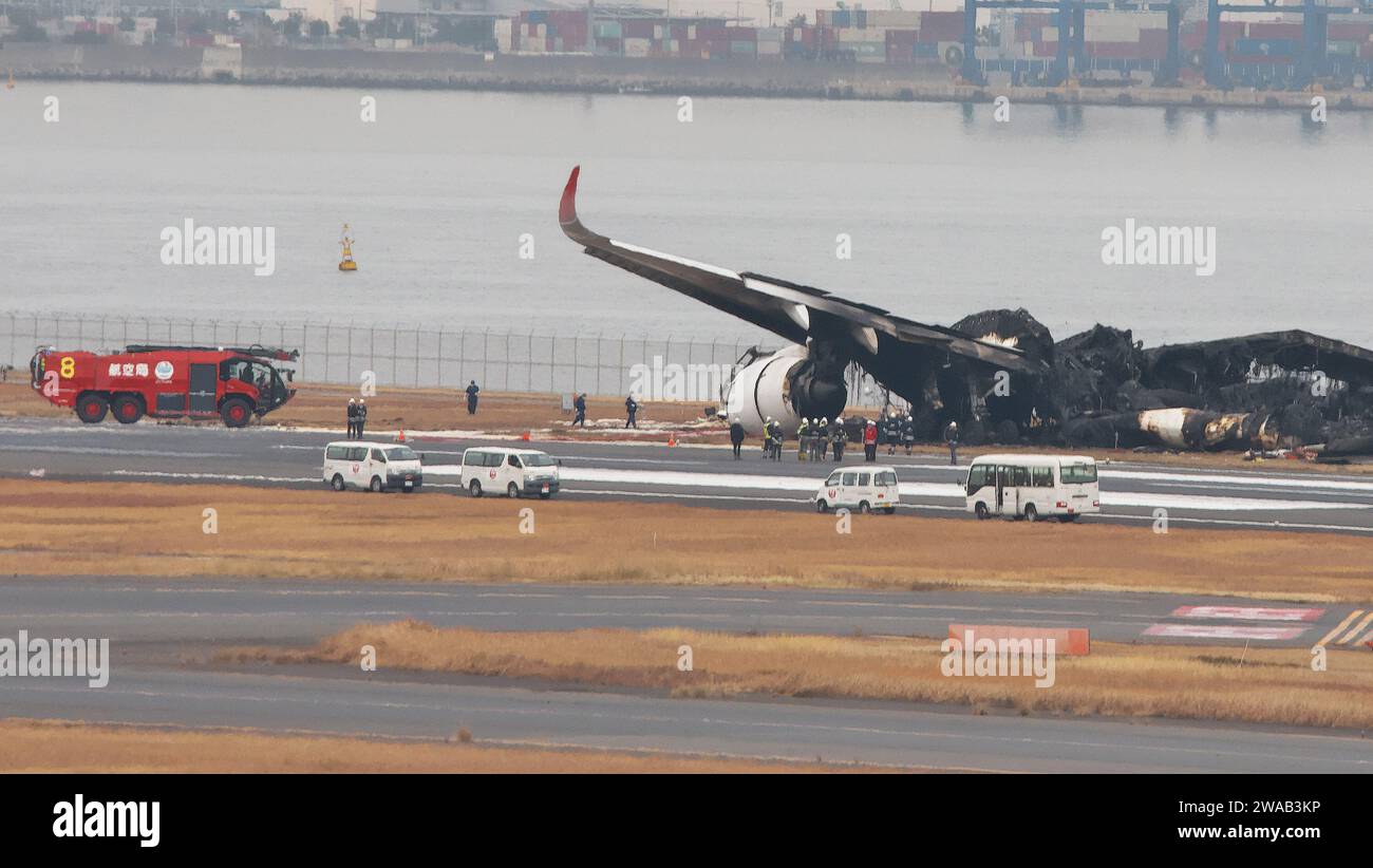 Tokio, Japan. Januar 2024. Beamte untersuchen ein verbranntes Flugzeug ...