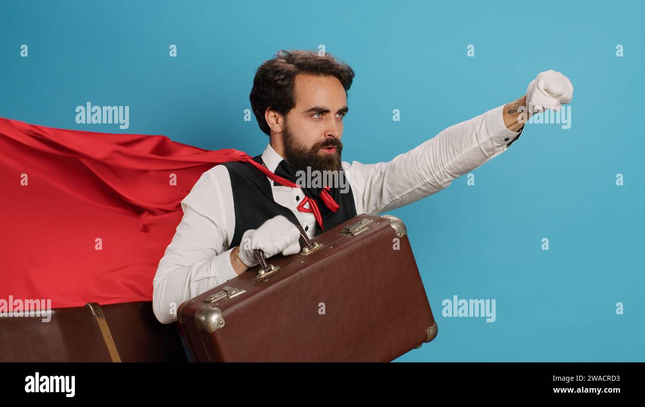 Hotelpagen, der mit cape als Superhuman fungiert, bieten Personen mit ...