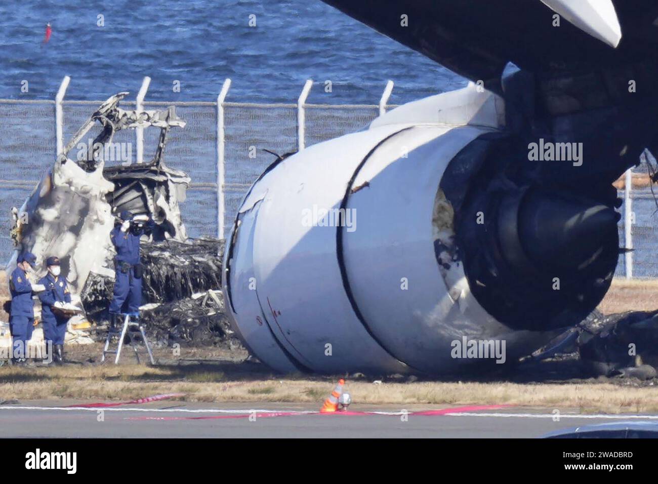 Police investigate the wreckage of Japan Airlines plane at Haneda airport on Thursday, Jan. 4 ...
