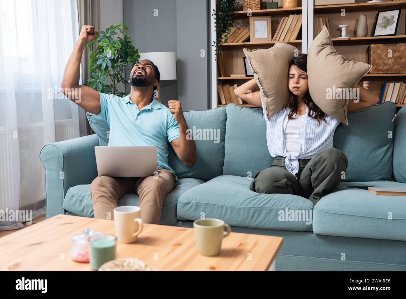 Ein junges Paar starrt an die Decke und schreit, weil ein Nachbar oben ...