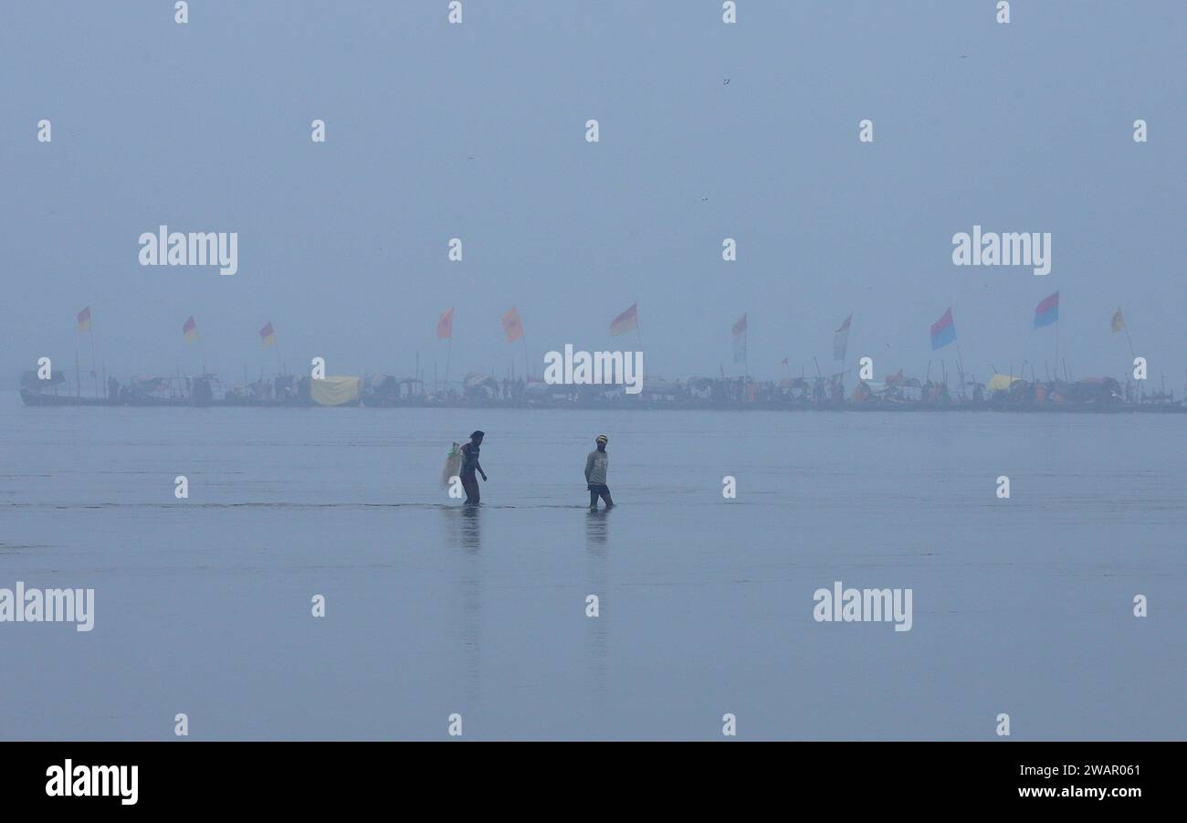Prayagraj, Indien. 6. Januar 2024, indische Fischer spazieren an einem ...