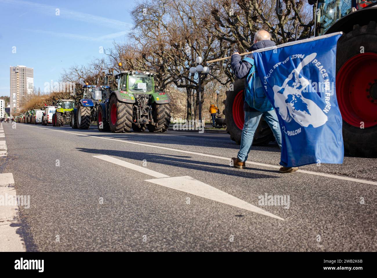 Ein Demonstrant trägt eine Friedensfahne bei einer Traktordemo in ...