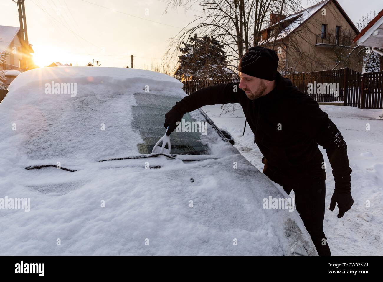 Ein Mann raubt Eis von seinem Auto, als die Temperaturen sanken und der ...