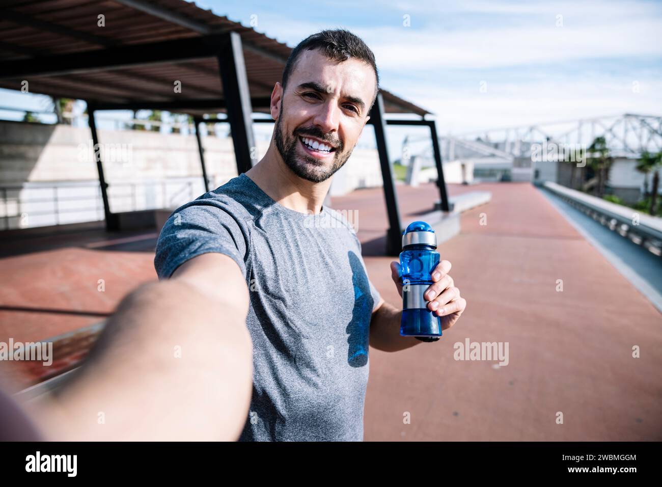 Runner man trinkt Wasser und macht ein Selfie nach dem Training draußen ...