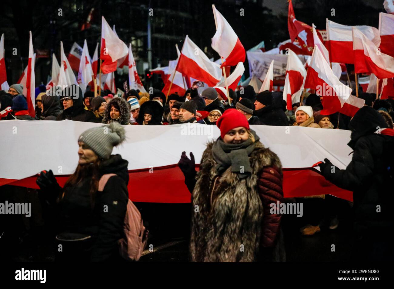Warschau, Polen, 11. Januar 2024. Menschenmassen, die polnische Nationalflaggen halten und von ...