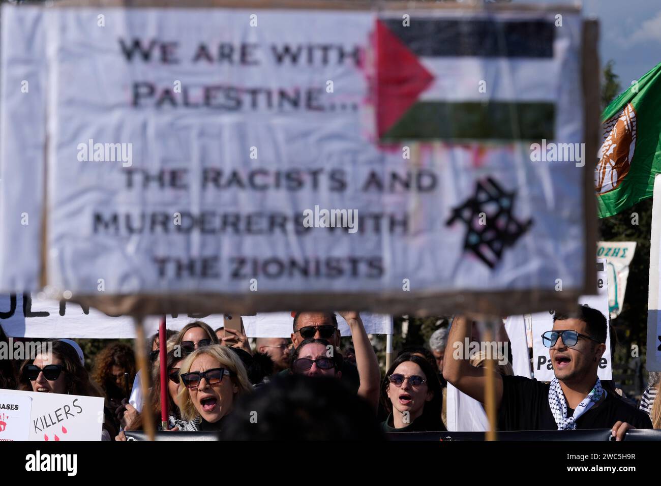 Demonstrators shout slogans, as they hold Palestine flags and placards ...