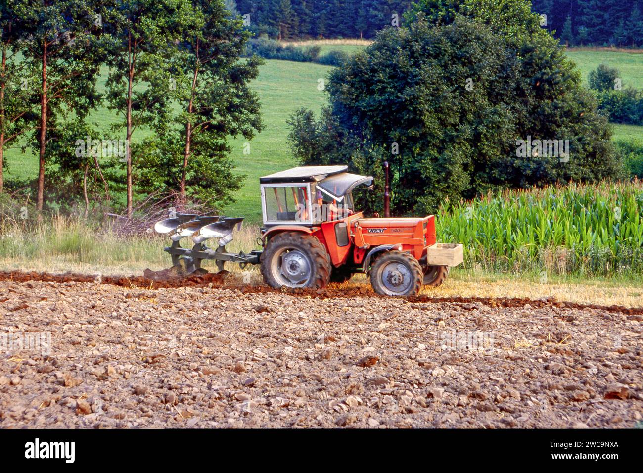 Bauer mit Traktor bei der Feldarbeit, pflügt den Acker ...