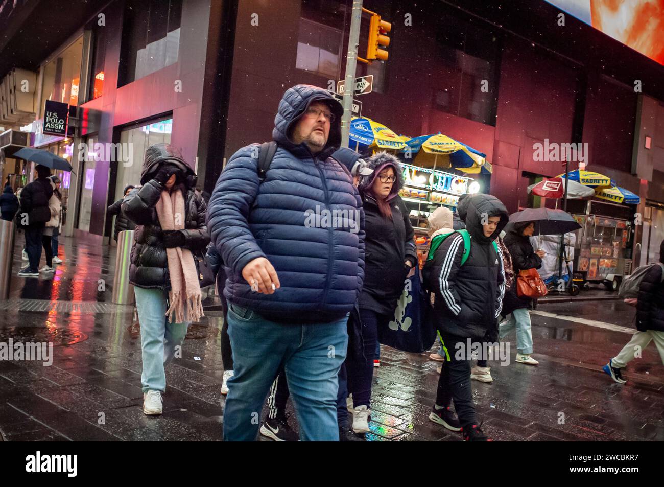 Besucher des Times Square am Sonntag, den 7. Januar 2024, kämpfen mit ...