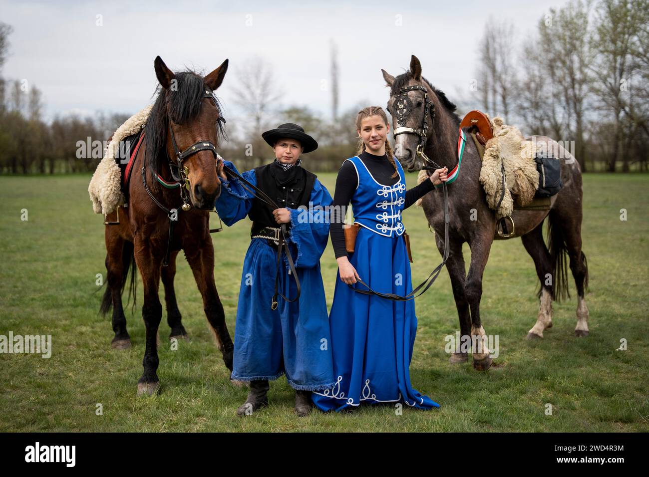Ein Junge und ein Mädchen in traditioneller blauer ungarischer ...