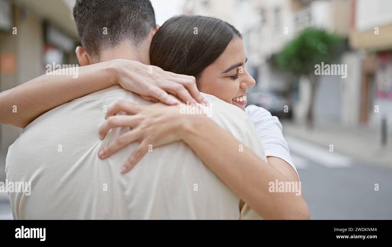 Liebevolle Frau, die einen Mann von hinten auf einer Stadtstraße ...
