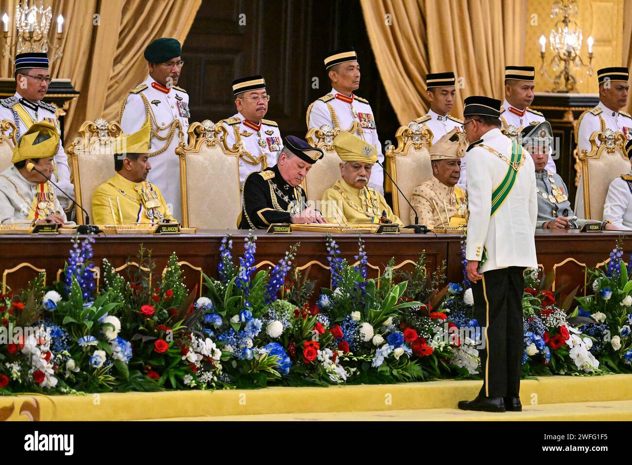 Sultan Ibrahim Sultan Iskandar, center left in front, signs documents during the oath taking ...