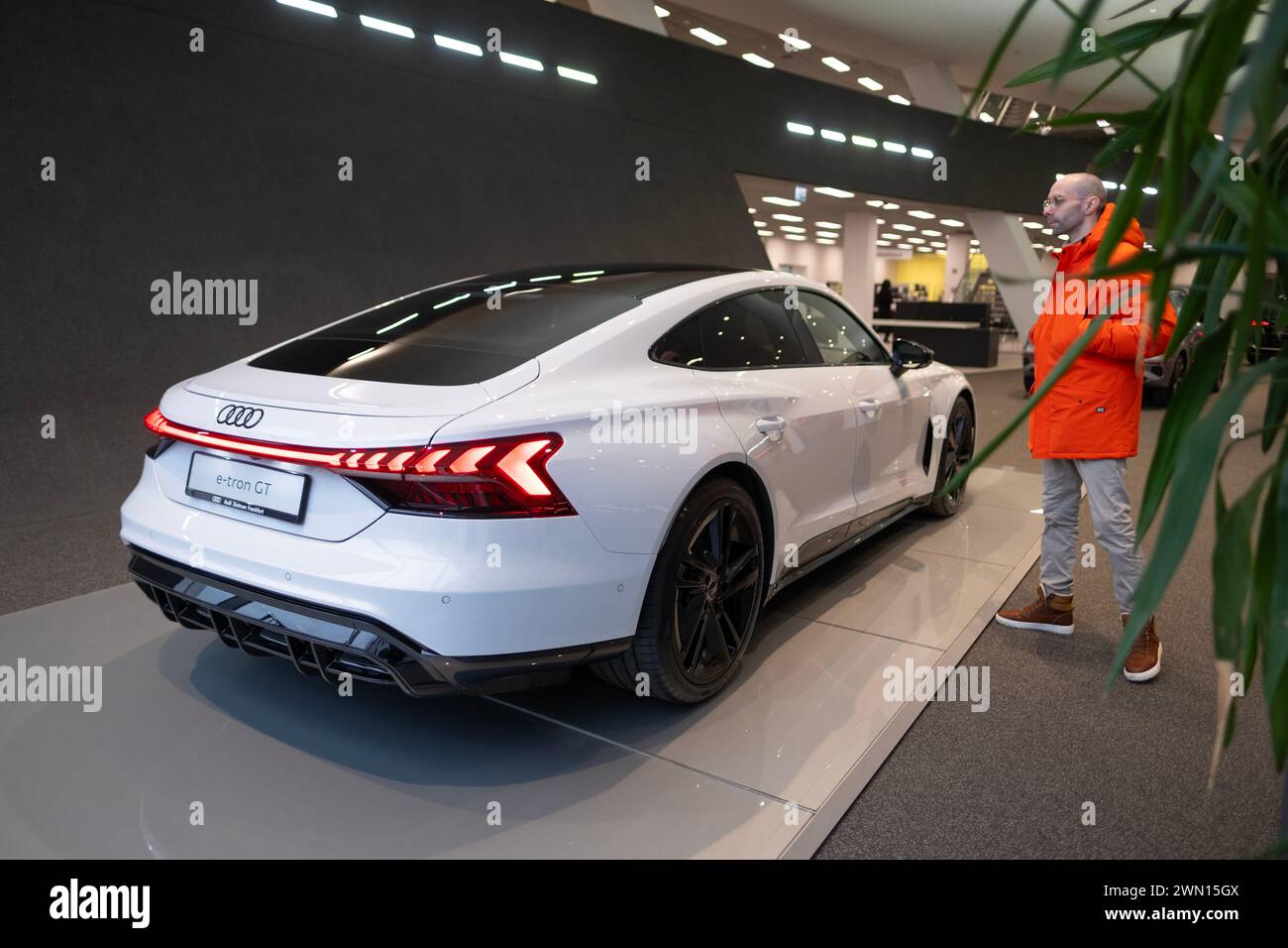 Junger Mann, der sich für ein weißes neues Elektroauto entscheidet Audi ... Junger Mann, der sich für ein weißes neues Elektroauto entscheidet Audi ...