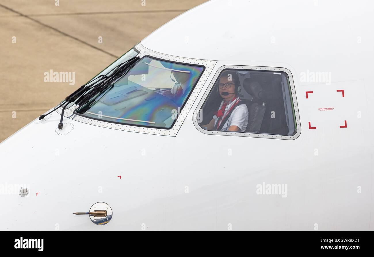 Eine Pilotin im Cockpit eines Embraer 190-E2 von Helvetic Airways ...