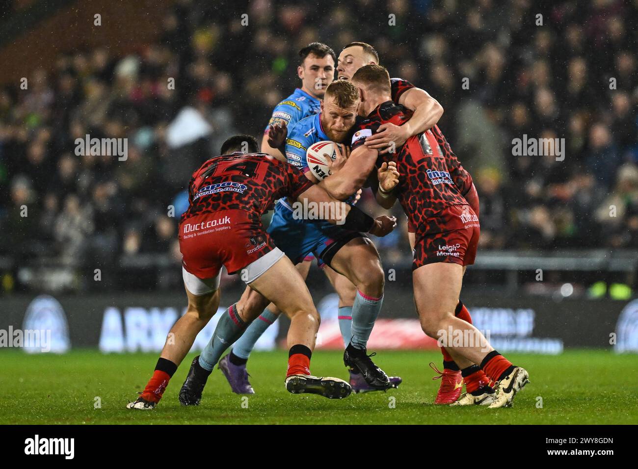 Luke Thompson von Wigan Warriors wird von Jack Hughes von Leigh ...