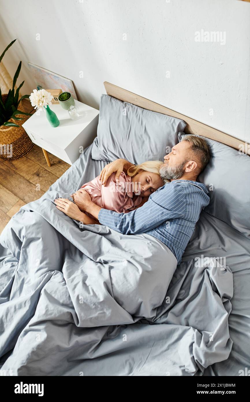 Ein reifes, liebevolles Paar in gemütlicher Hauswäsche, das zusammen im ...