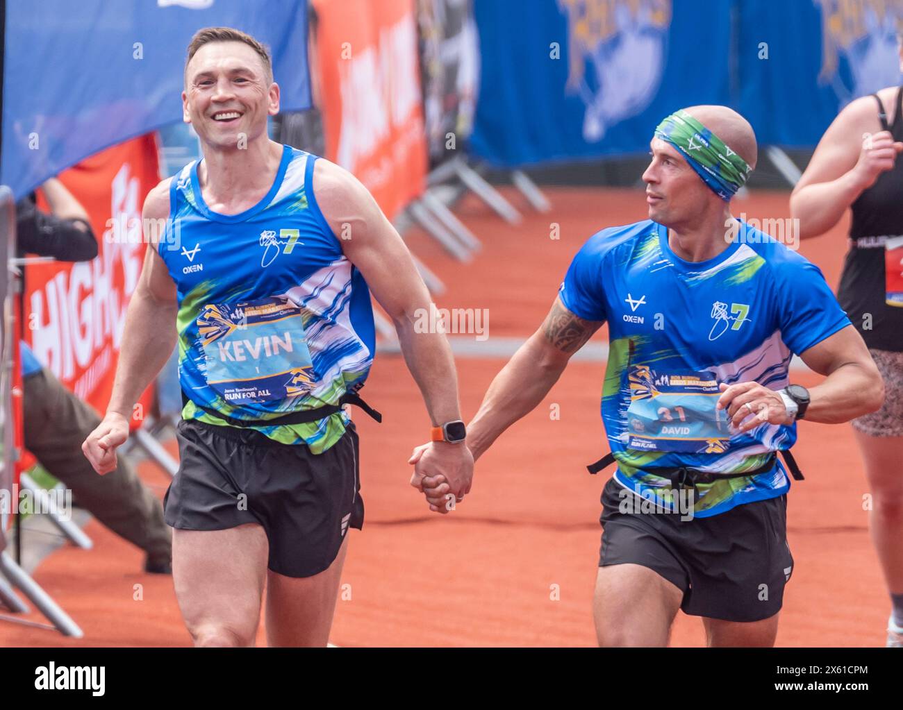 Kevin Sinfield und David Spencer (rechts) überqueren die Strecke, um ...