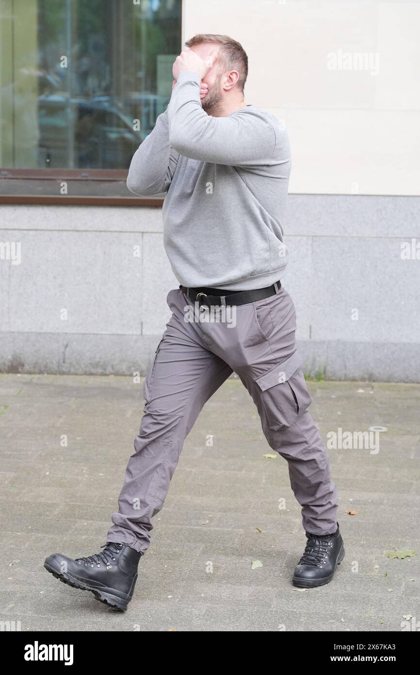 Matthew Trickett bedeckt sein Gesicht, als er den Westminster ...