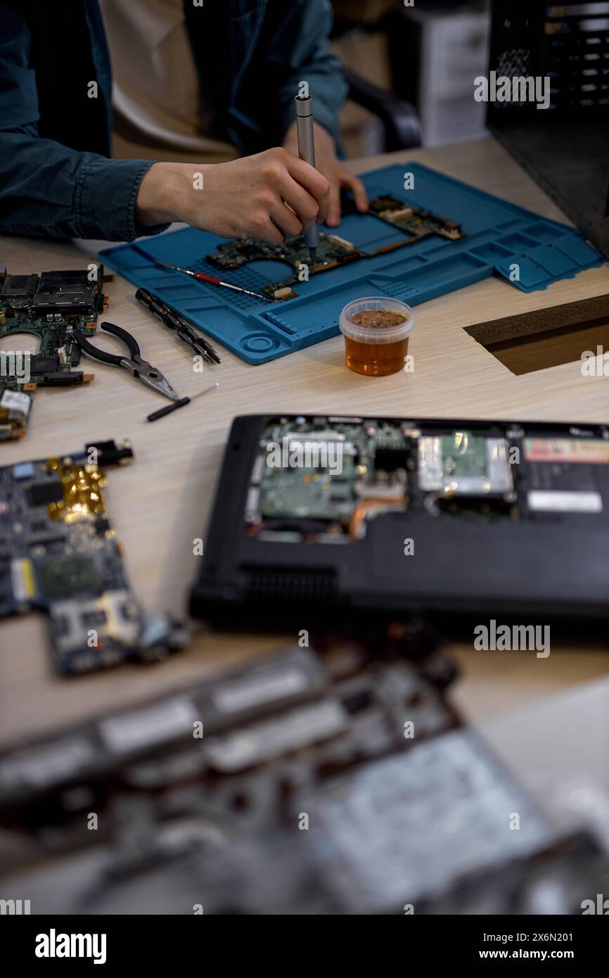 Beschnittene männliche Hände reparieren Teile in demontiertem Laptop ...