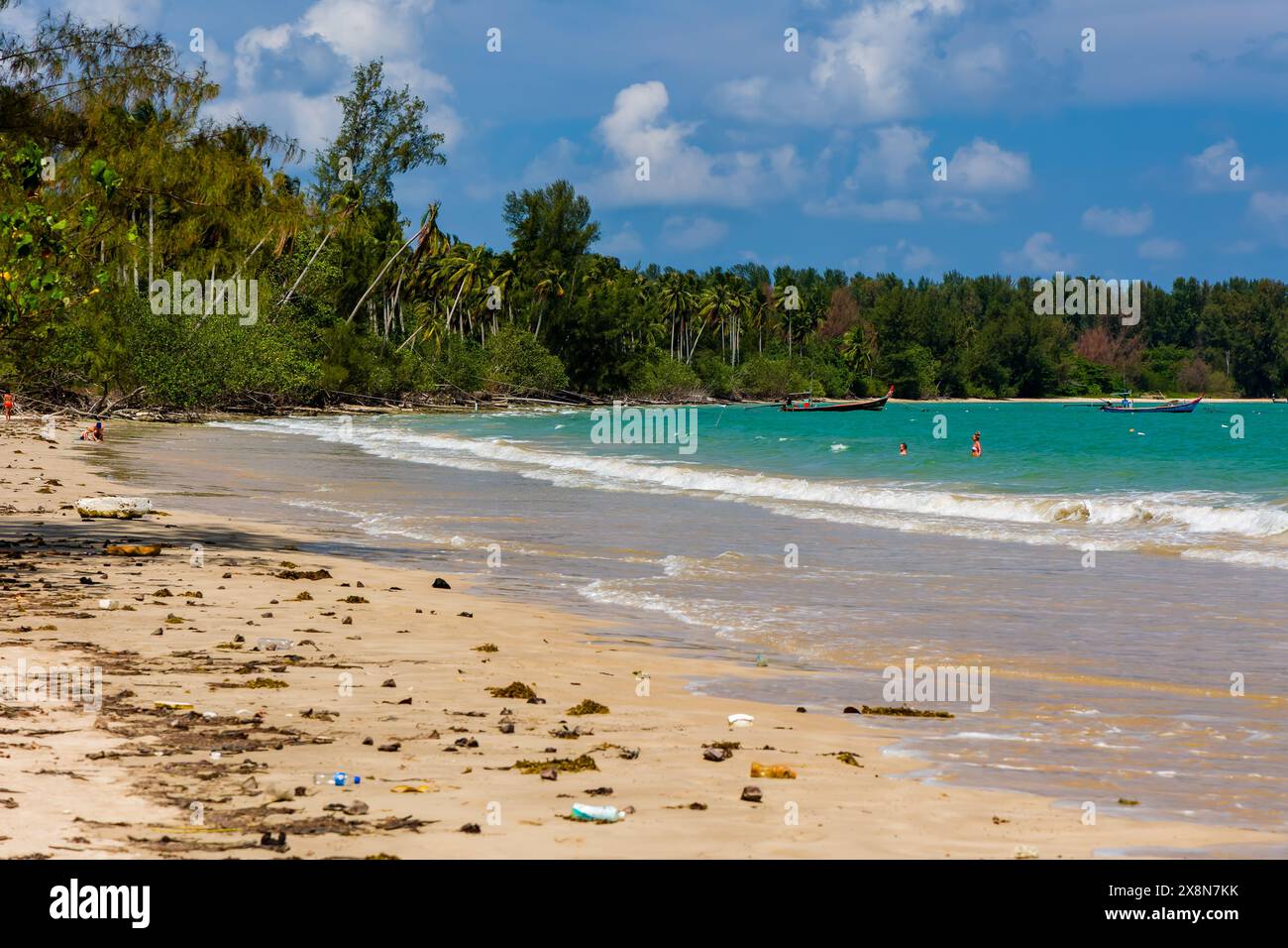 Plastikflaschen und anderer Müll wurden an einen tropischen Sandstrand ...