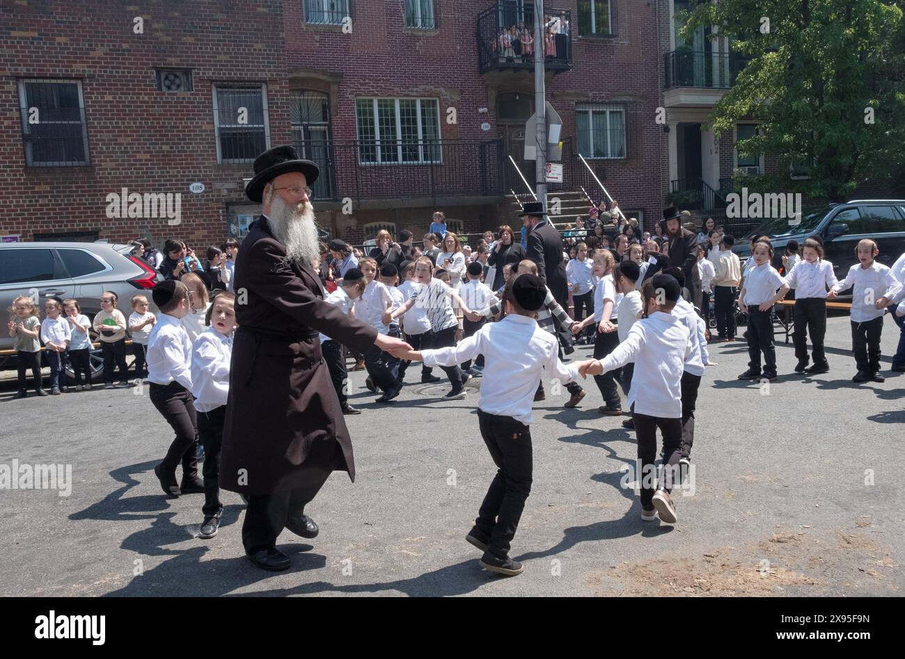 Ein Rabbiner und seine Schüler tanzen bei einer lag B'Omer-Feier auf ...