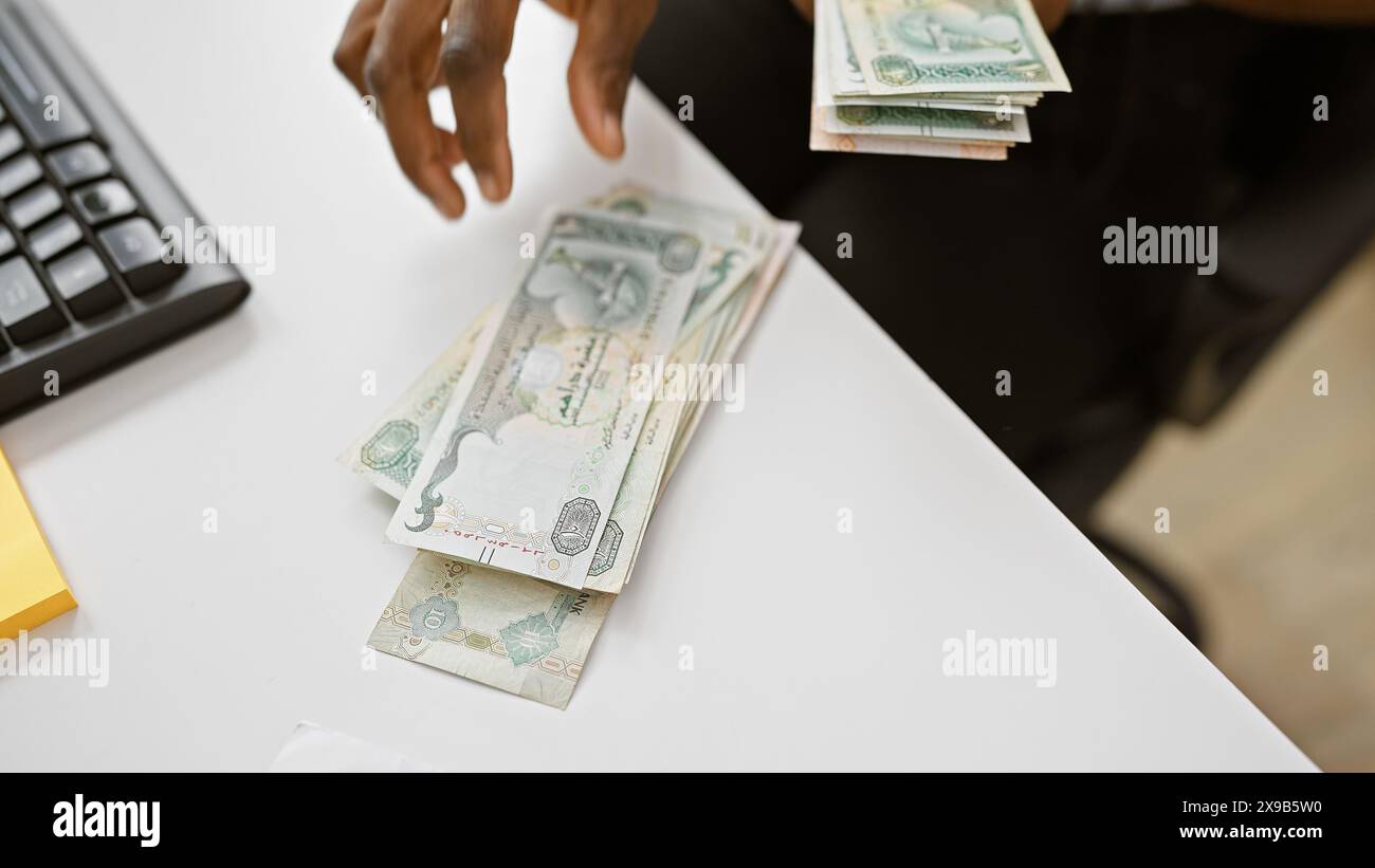 Afrikanische Frau zählt Dirham der vae an ihrem Schreibtisch und ...