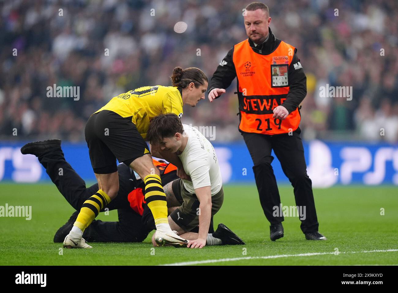 Ein Eindringling auf dem Spielfeld wird von Borussia Dortmunds Marcel ...