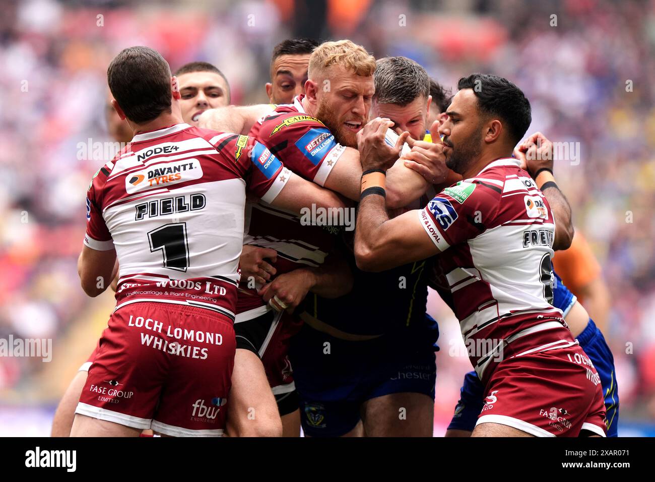 Warrington Wolves' Zane Musgrove (versteckt) wird von Wigan Warriors ...