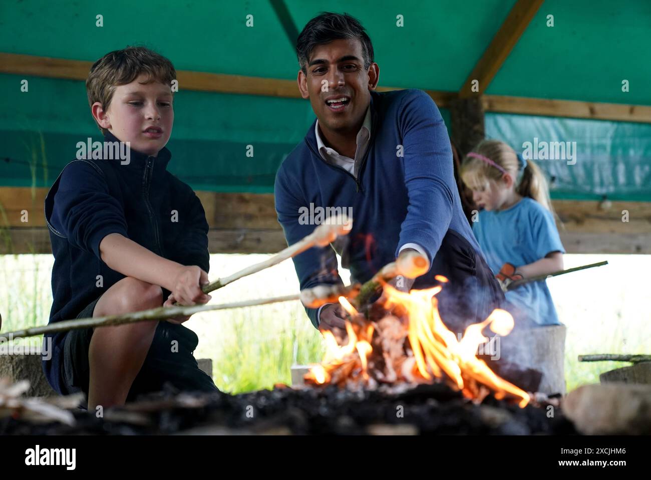 Premierminister Rishi Sunak toast Brot am offenen Feuer mit Kindern ...
