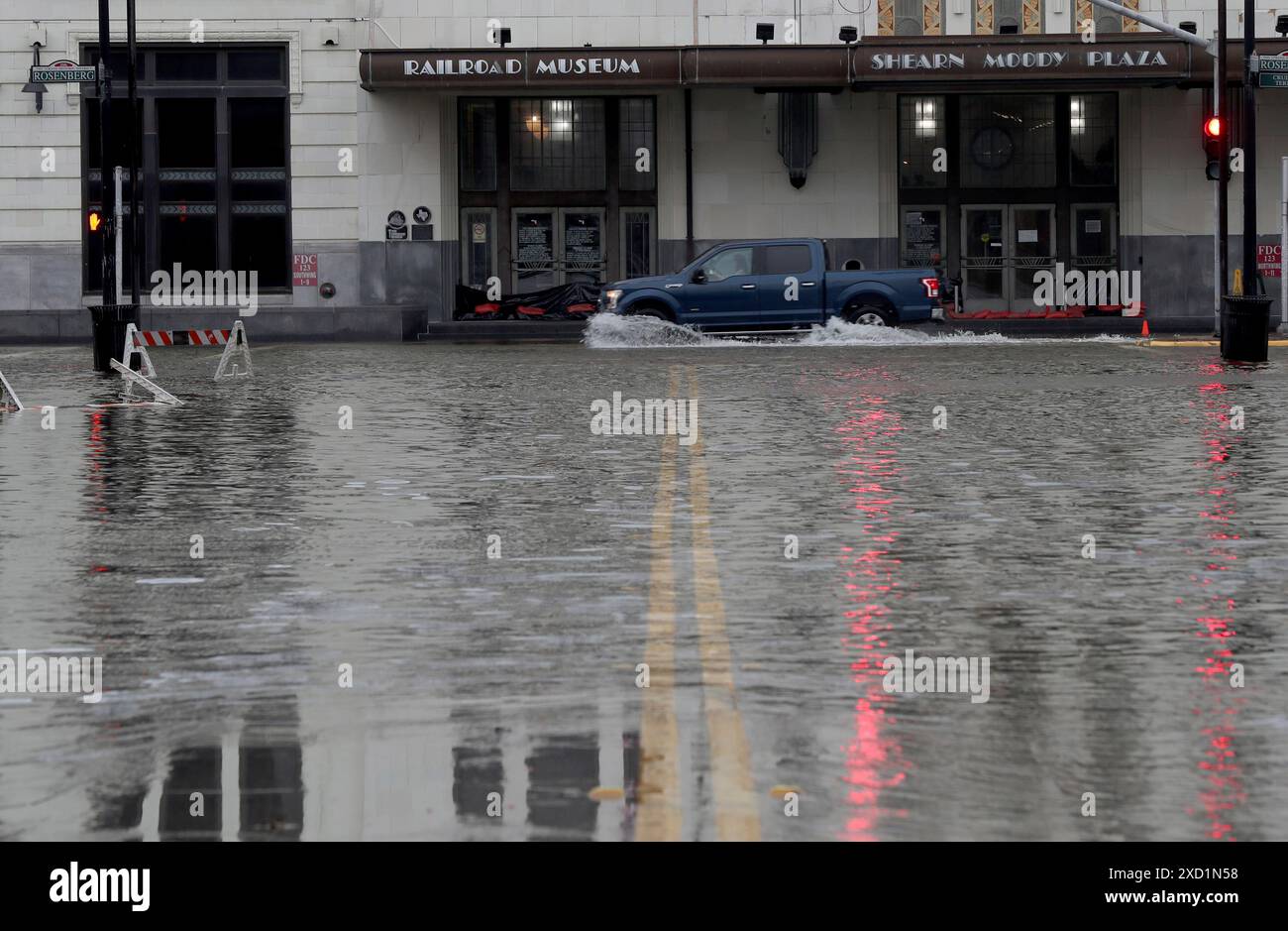 A vehicle drives through flood waters on 25th and Strand streets in ...