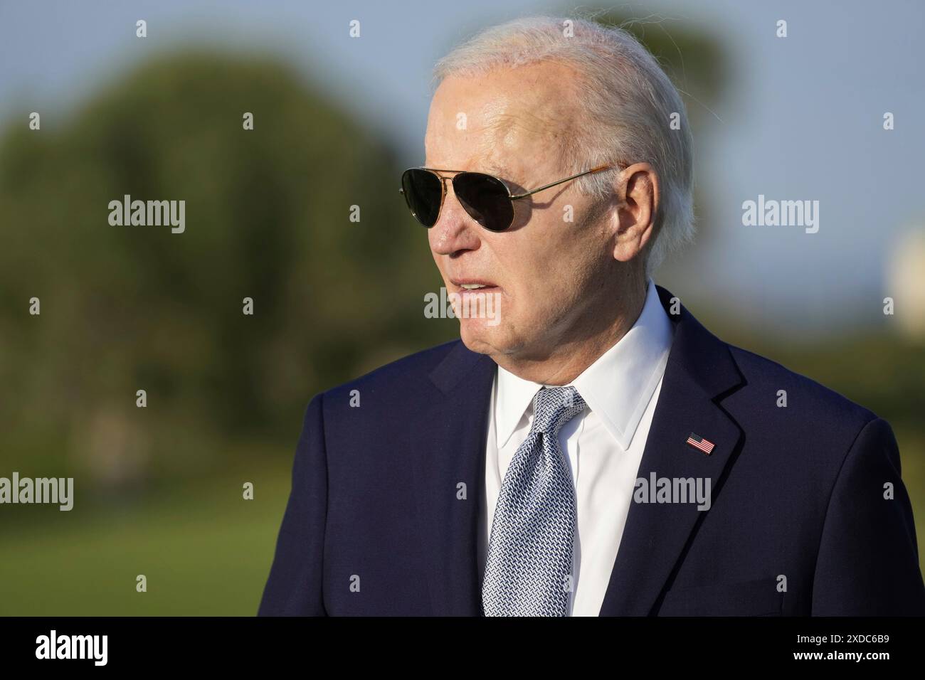 FILE - President Joe Biden answers a question as he watches a skydiving demonstration, at the G7 ...
