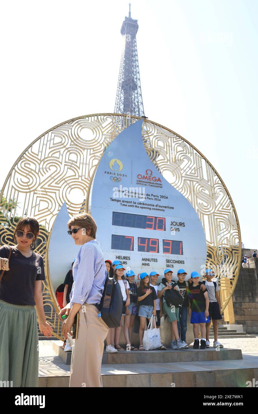 People pose in front of the Countdown Clock for the Paris Olympics ...